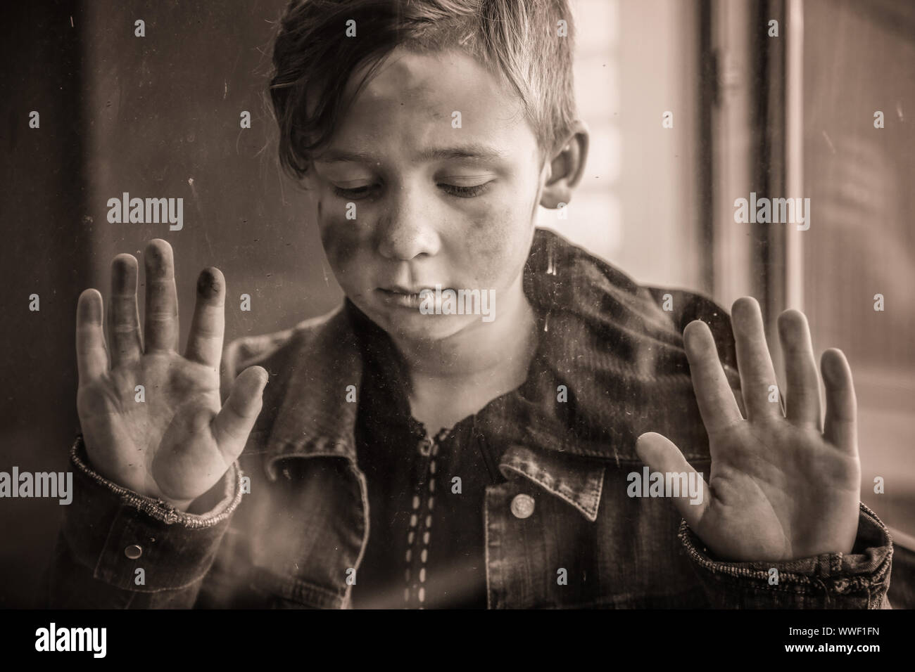 Homeless little boy near window indoors, view through glass Stock Photo ...