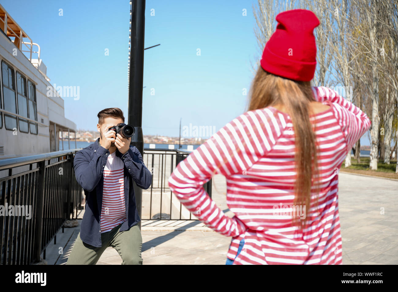 Photographer taking picture of beautiful woman on embankment Stock ...