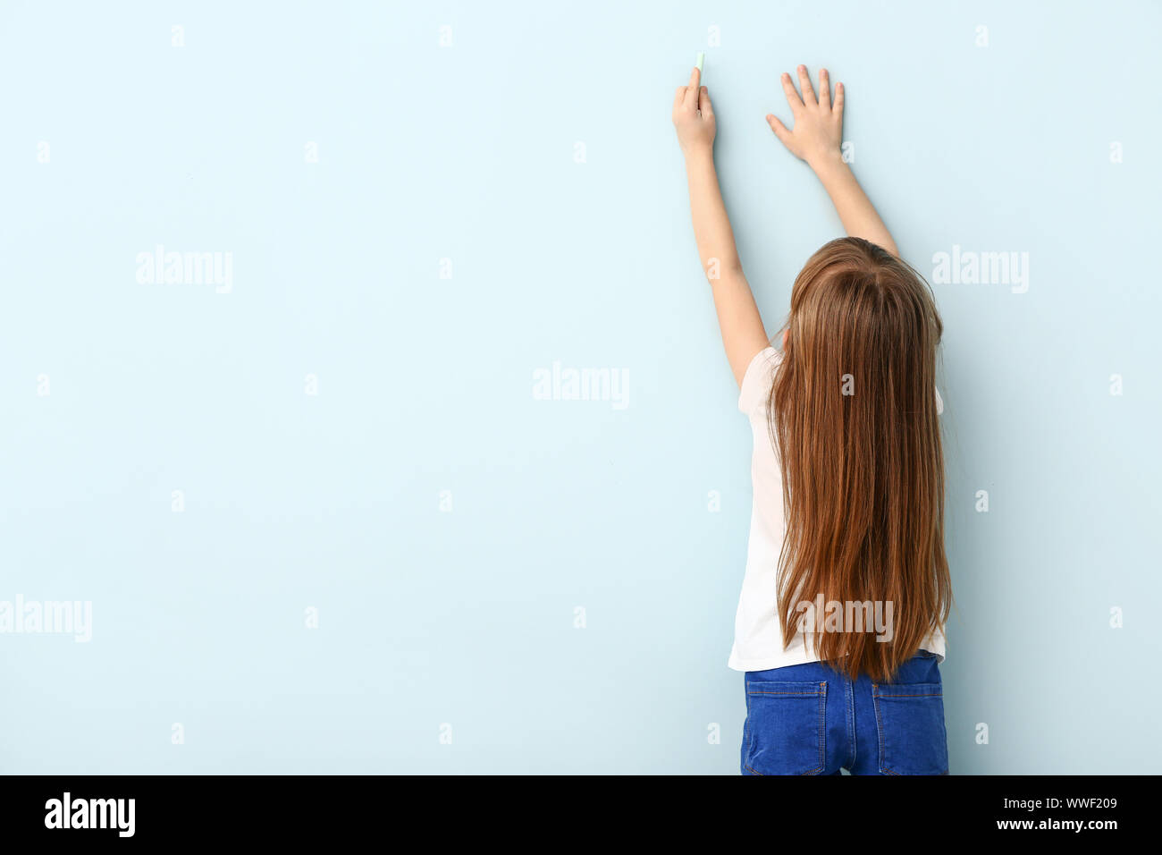Little girl drawing on color wall Stock Photo - Alamy