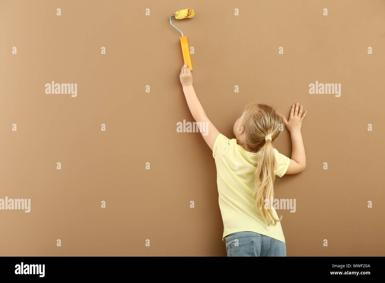 Little girl painting color wall Stock Photo - Alamy