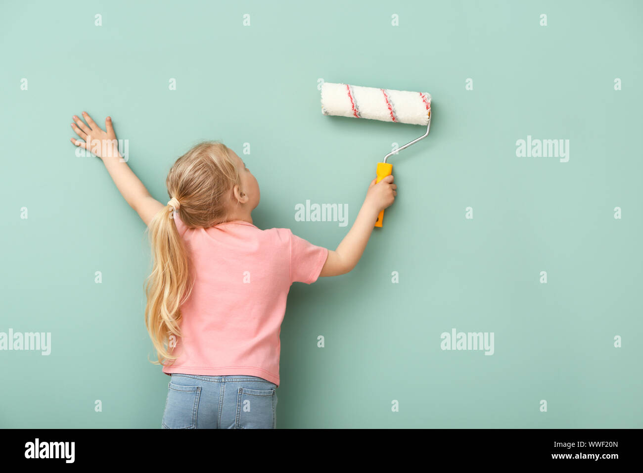 Little girl painting color wall Stock Photo - Alamy