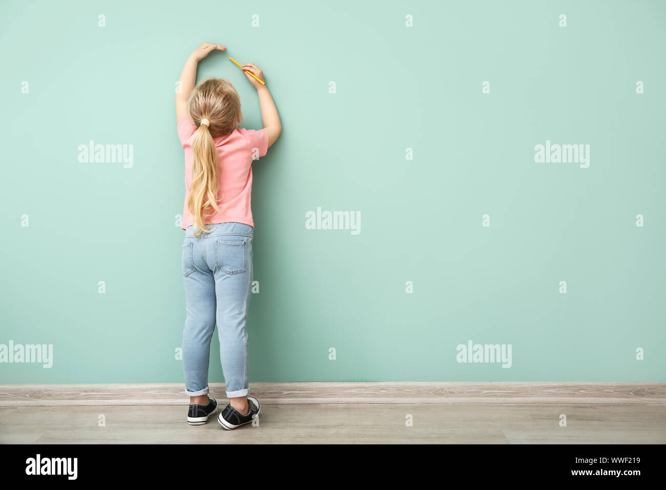 Little girl drawing on color wall Stock Photo - Alamy