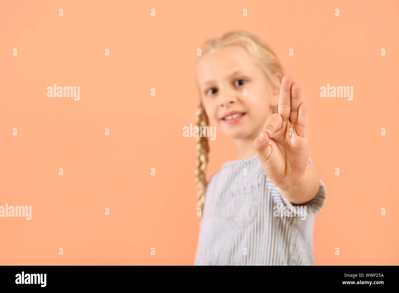 Little deaf mute girl using sign language on color background Stock ...