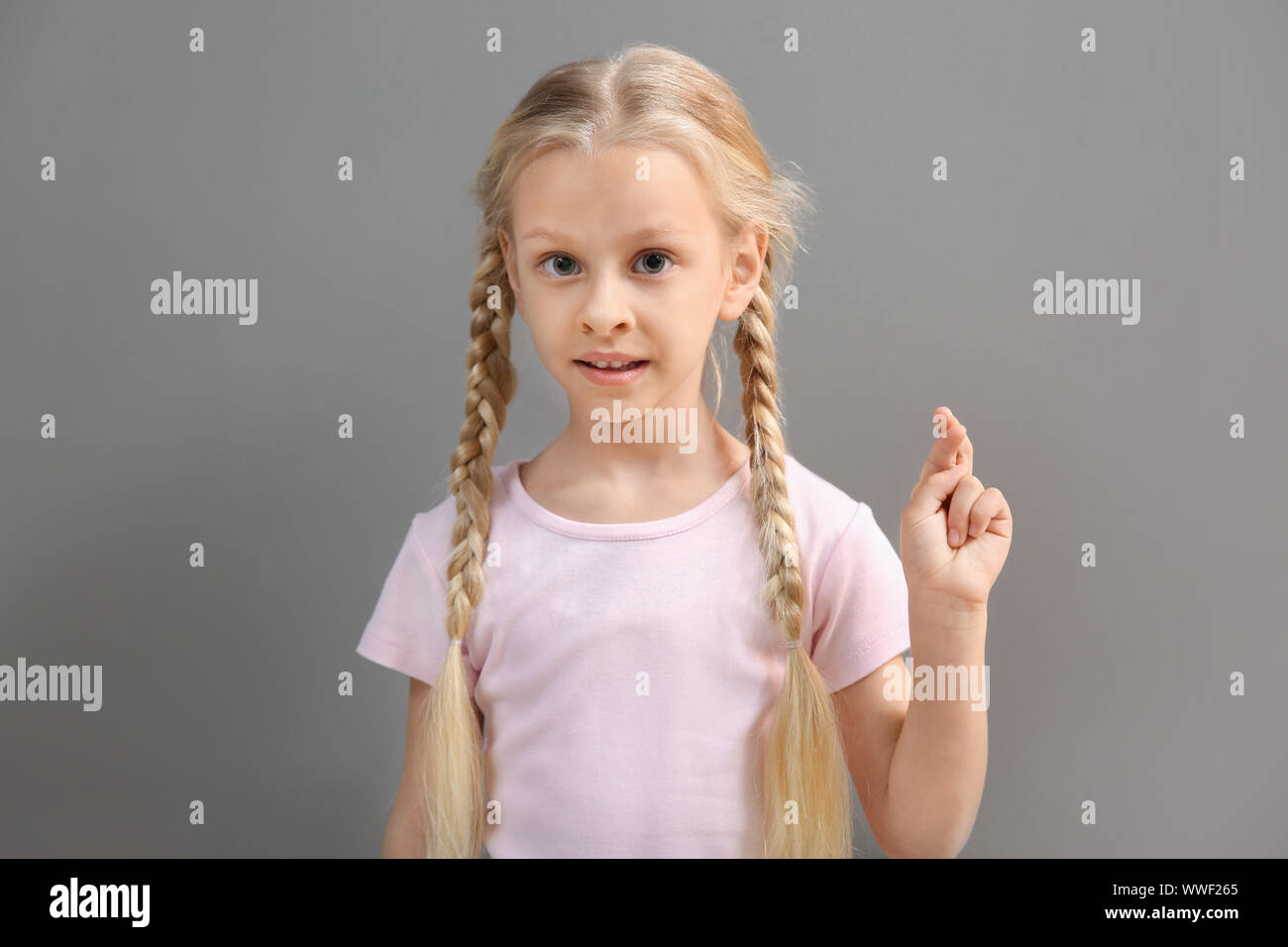 Little deaf mute girl using sign language on grey background Stock ...
