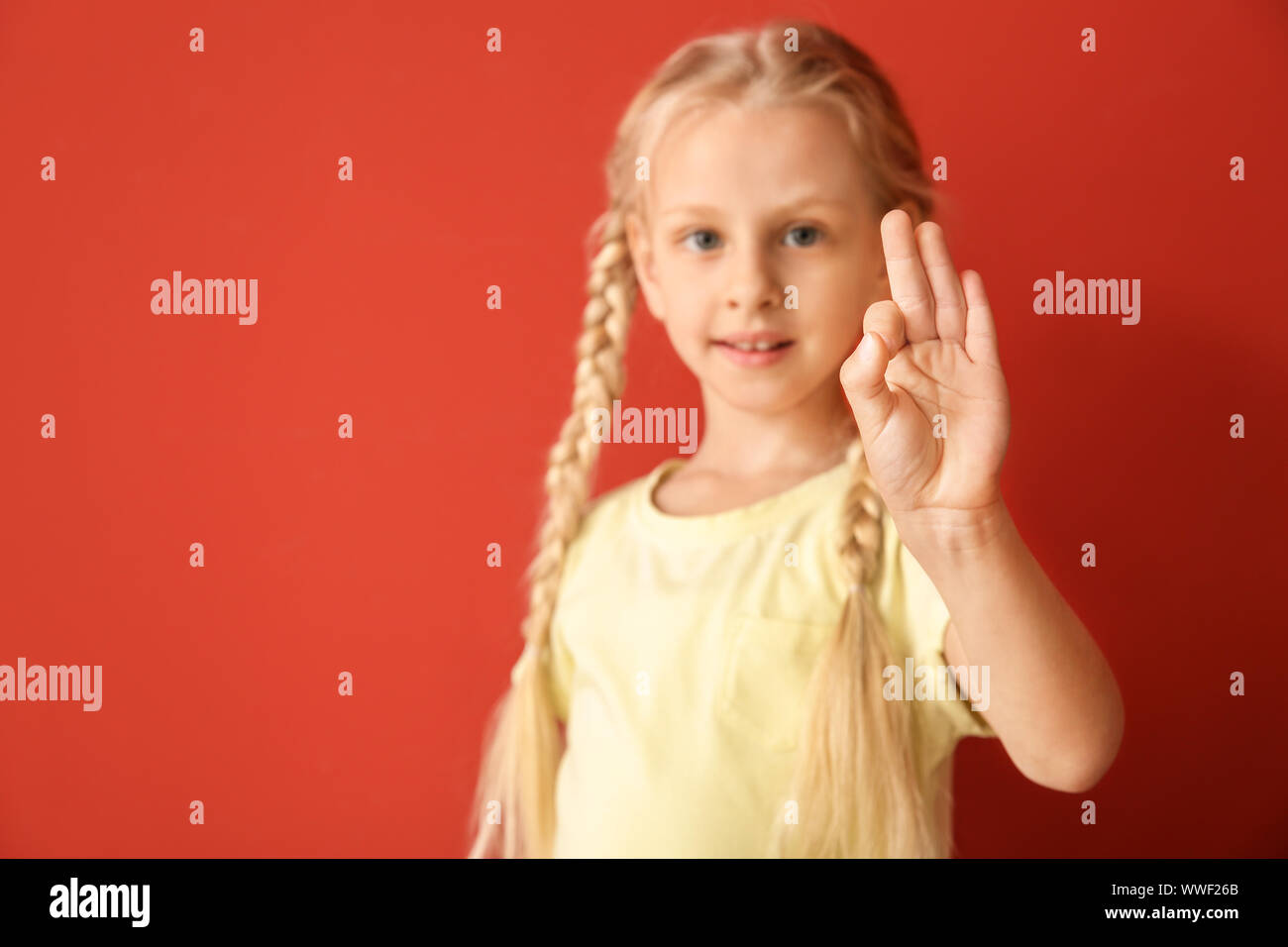 Little deaf mute girl using sign language on color background Stock ...