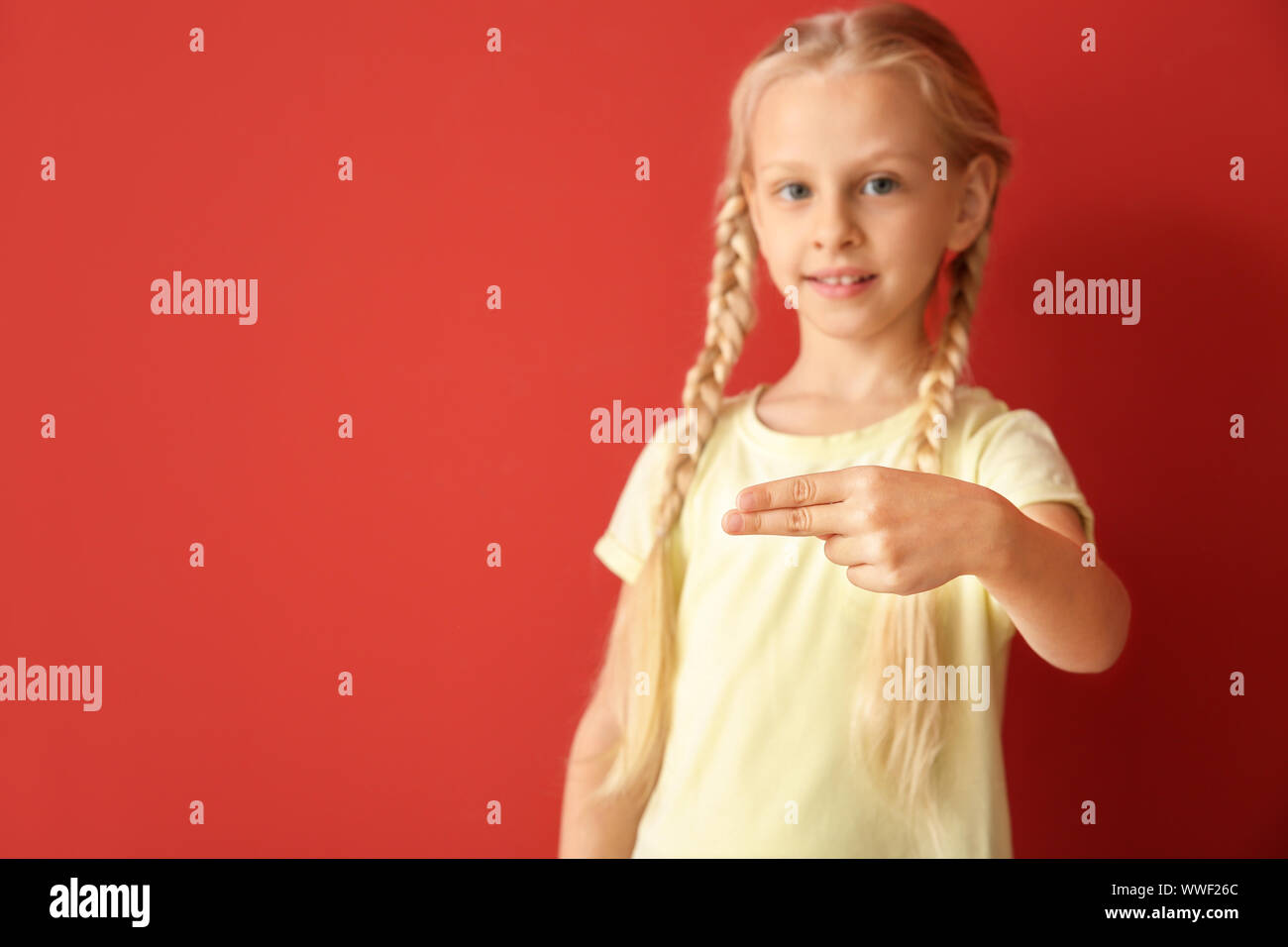 Little deaf mute girl using sign language on color background Stock ...