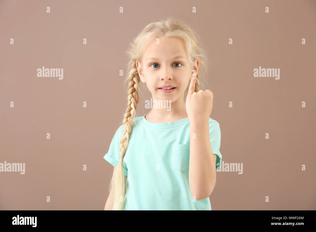 Little deaf mute girl using sign language on color background Stock ...
