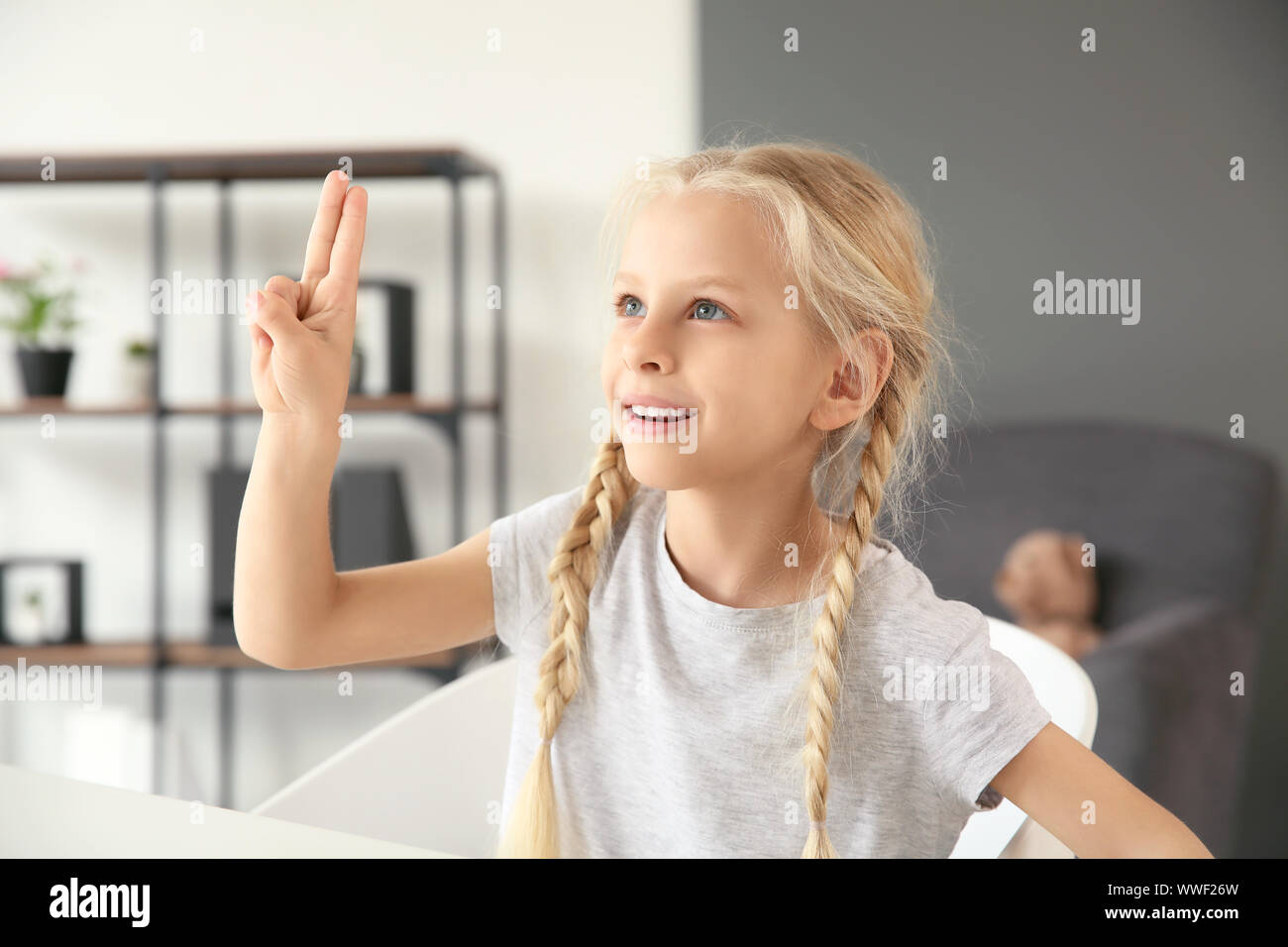 Little deaf mute girl using sign language at home Stock Photo - Alamy