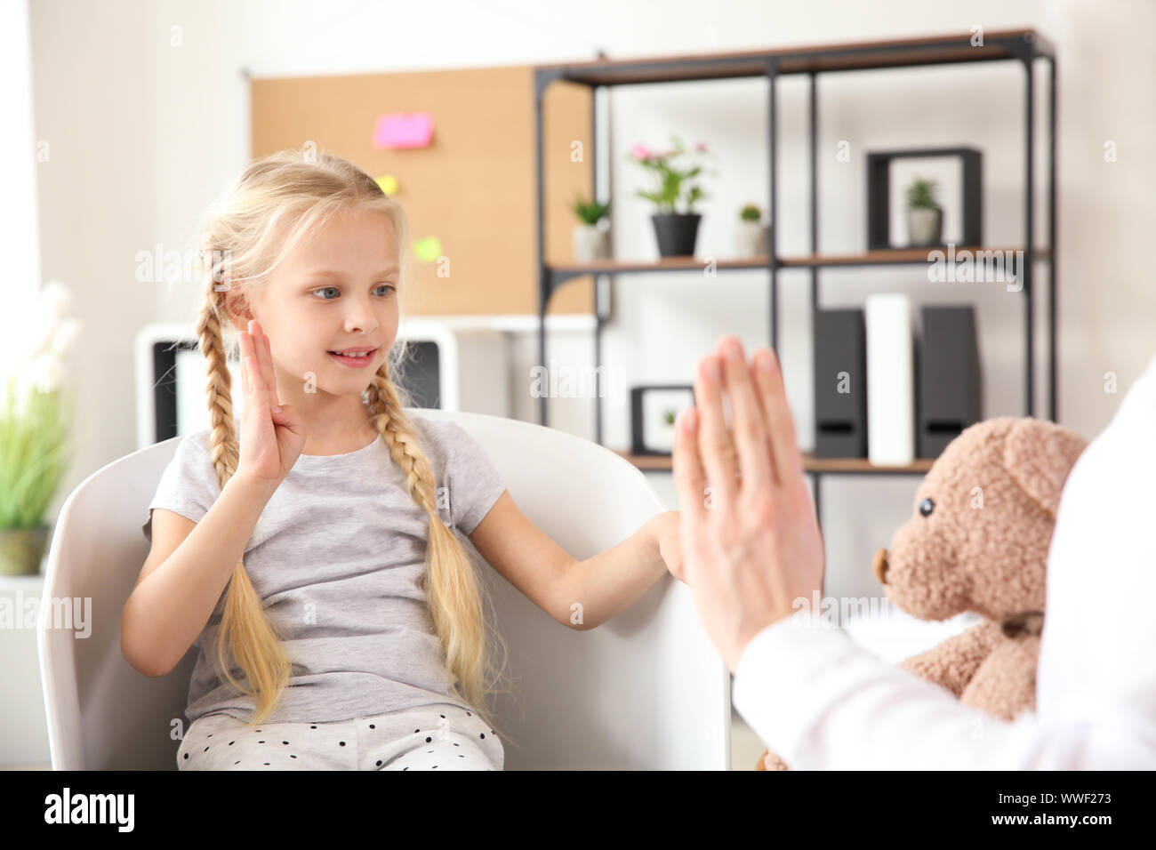 Mother teaching her deaf mute daughter to use sign language at home ...