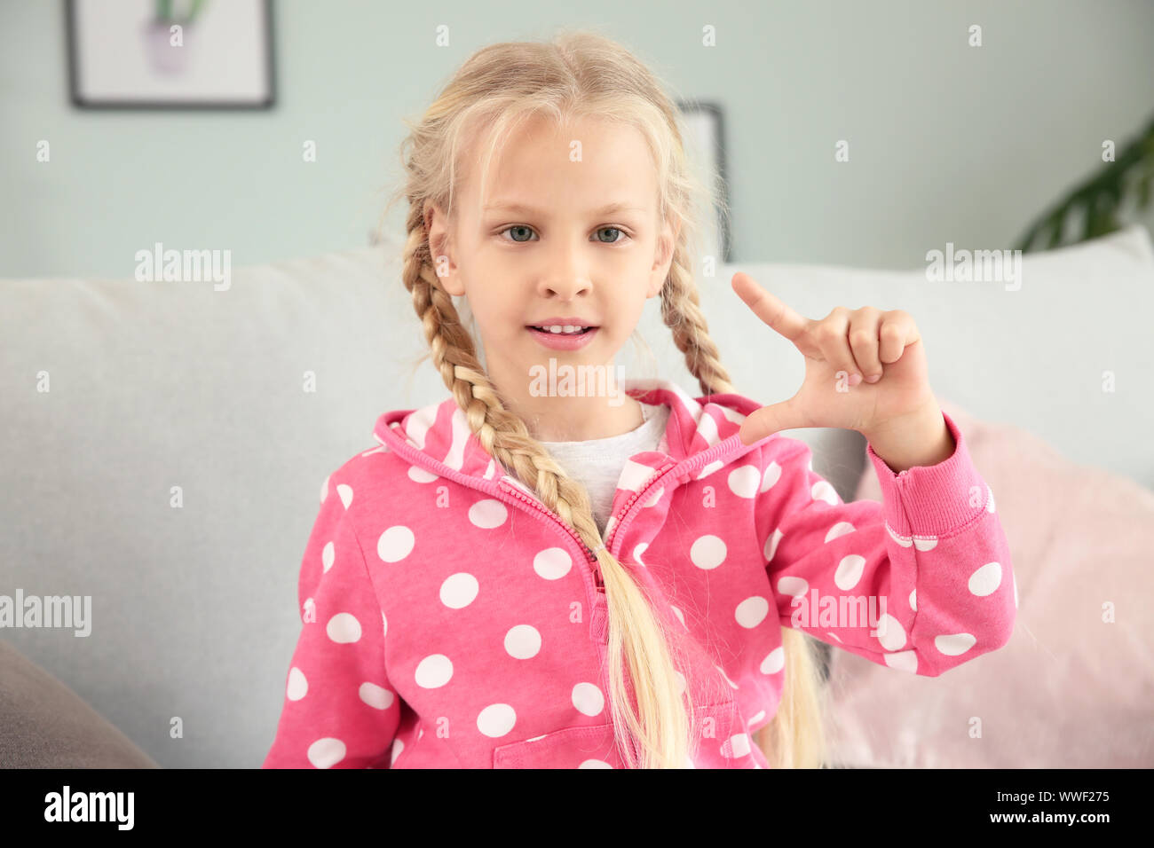 Little deaf mute girl using sign language at home Stock Photo - Alamy
