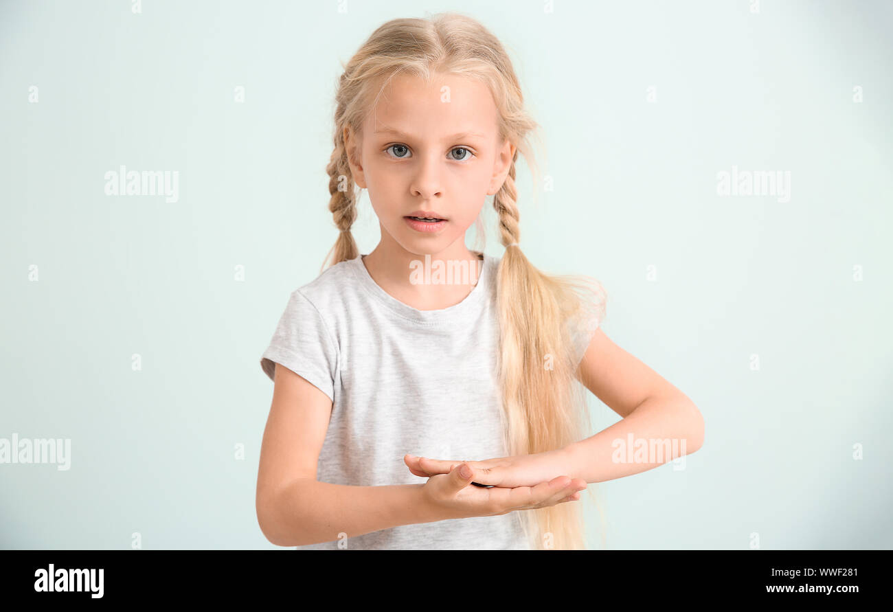 Little deaf mute girl using sign language on light background Stock ...