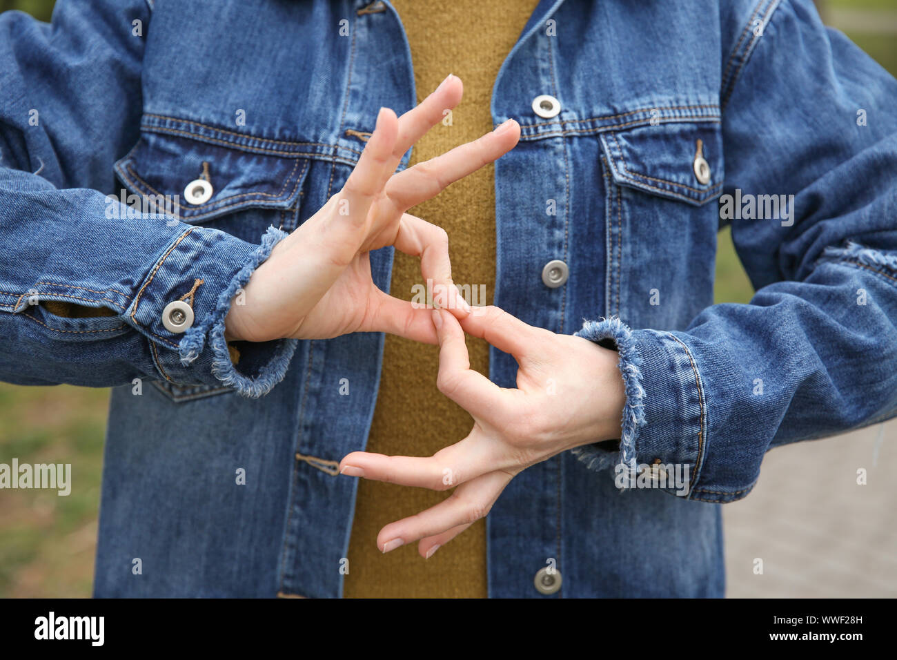 Young deaf mute woman using sign language outdoors Stock Photo - Alamy