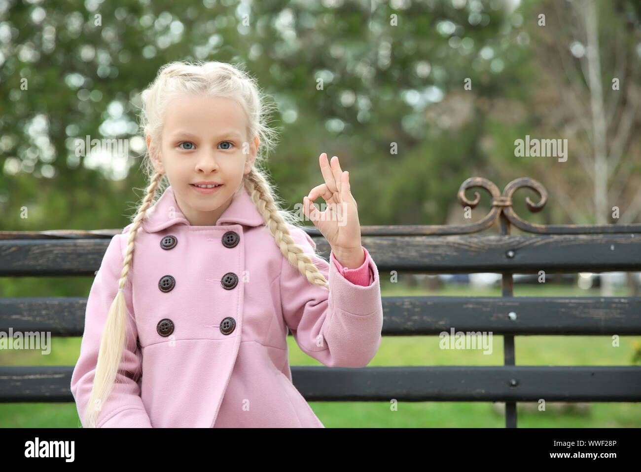 Little deaf mute girl using sign language outdoors Stock Photo - Alamy