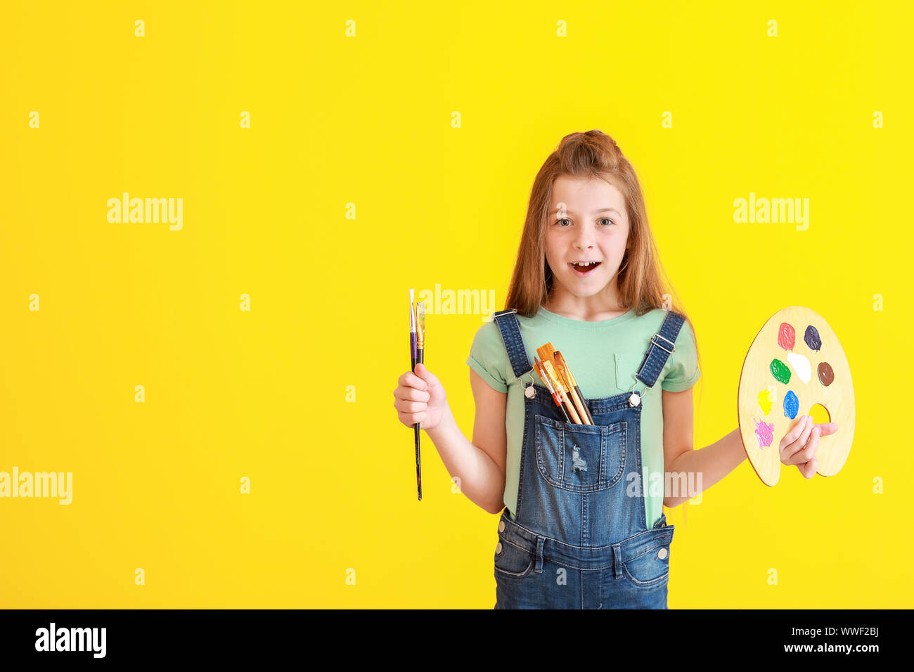 Cute little artist on color background Stock Photo - Alamy