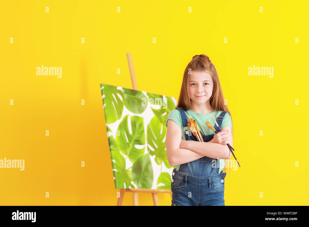 Cute little artist on color background Stock Photo - Alamy