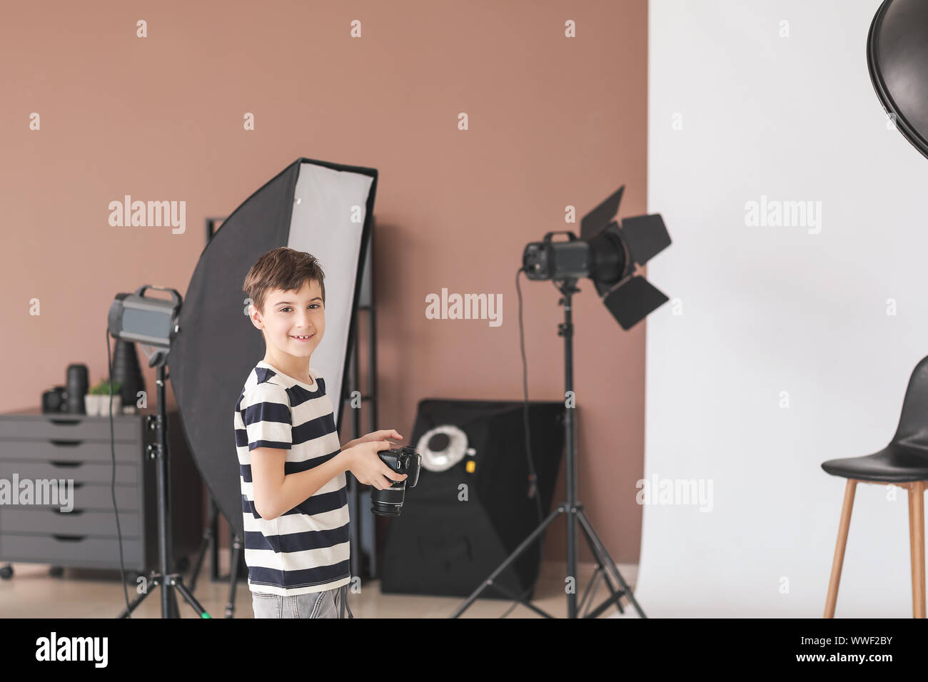 Cute little photographer in professional studio Stock Photo - Alamy
