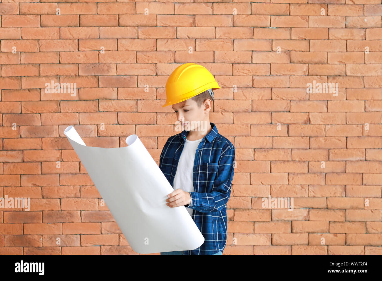 Cute little architect near brick wall Stock Photo - Alamy