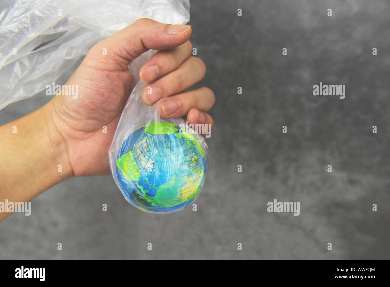 Plastic world or World Environment Day Concept / Hand holds the planet ...