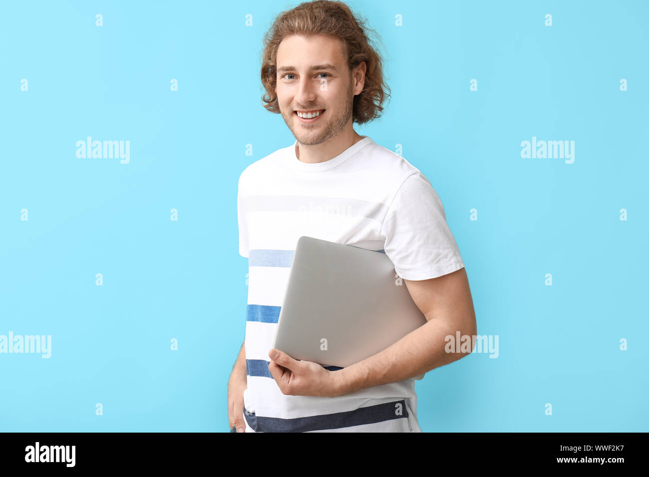 Male programmer with laptop on color background Stock Photo - Alamy