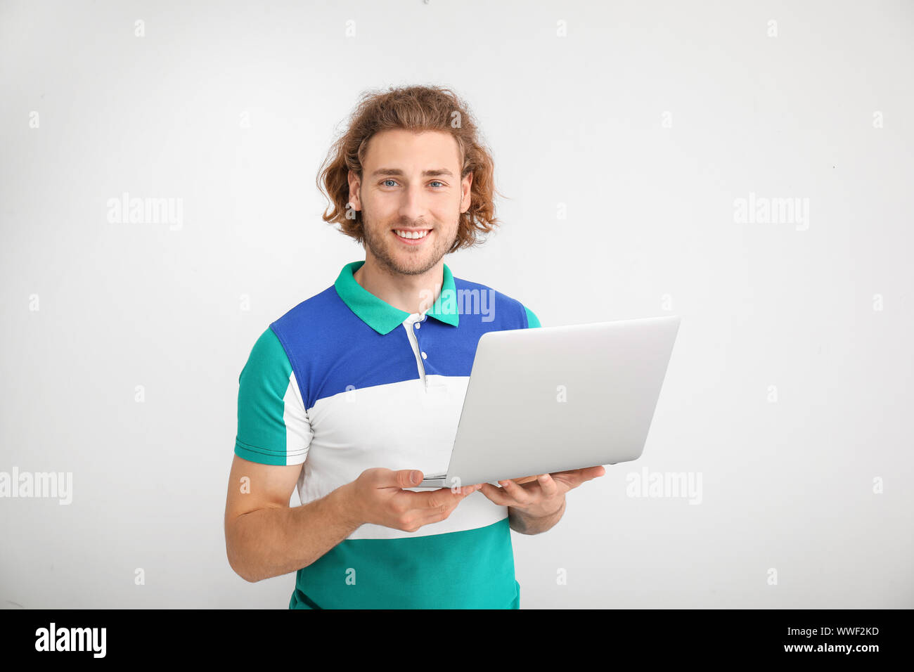 Male programmer with laptop on light background Stock Photo - Alamy