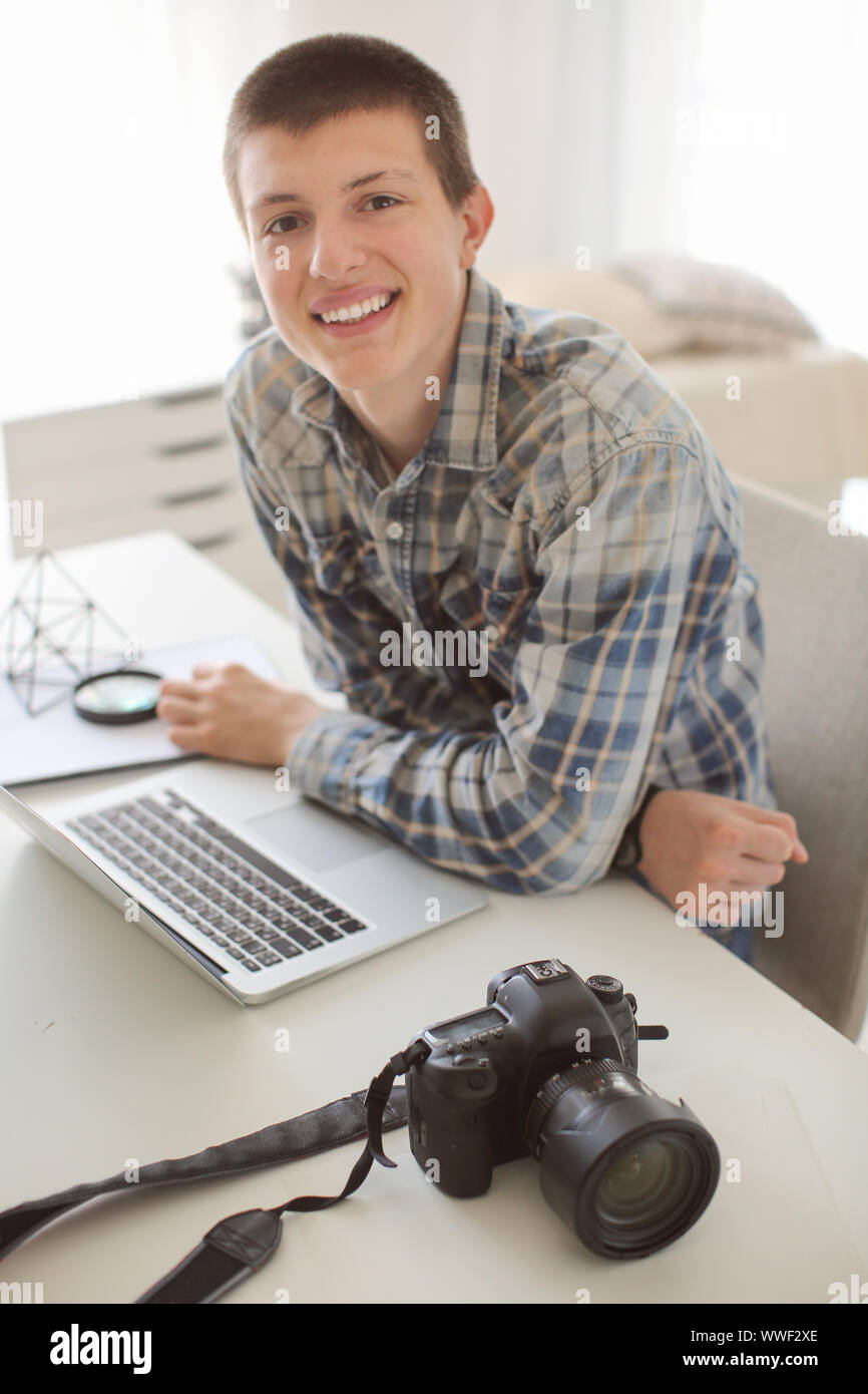 Teenage boy with photo camera and laptop at home Stock Photo - Alamy