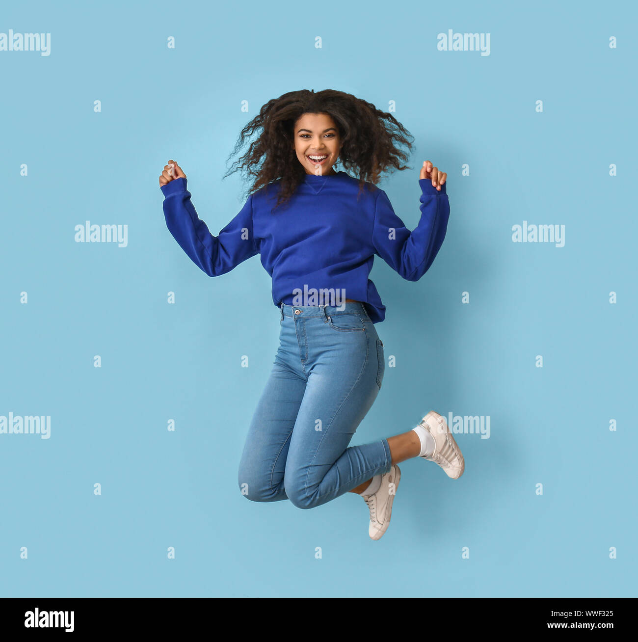 Jumping African-American woman on color background Stock Photo - Alamy