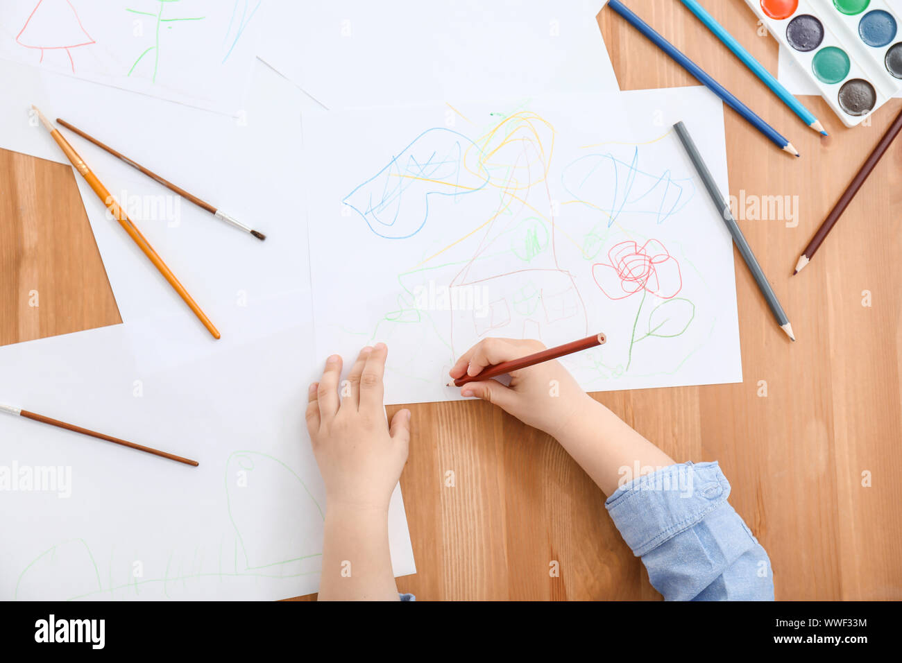 Cute little child drawing at table, top view Stock Photo - Alamy