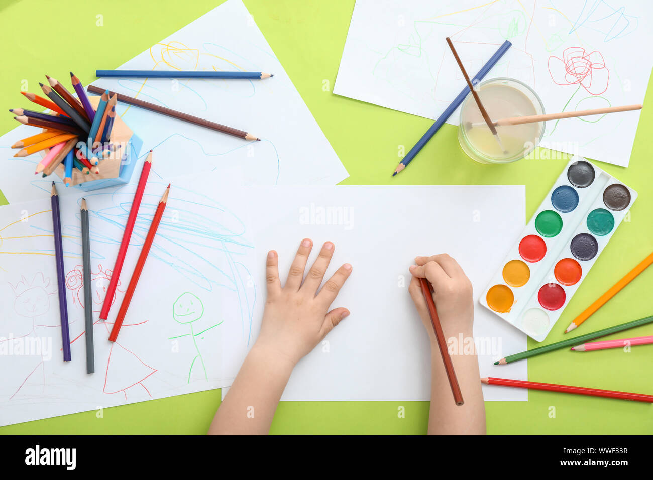 Cute little child drawing at table, top view Stock Photo - Alamy