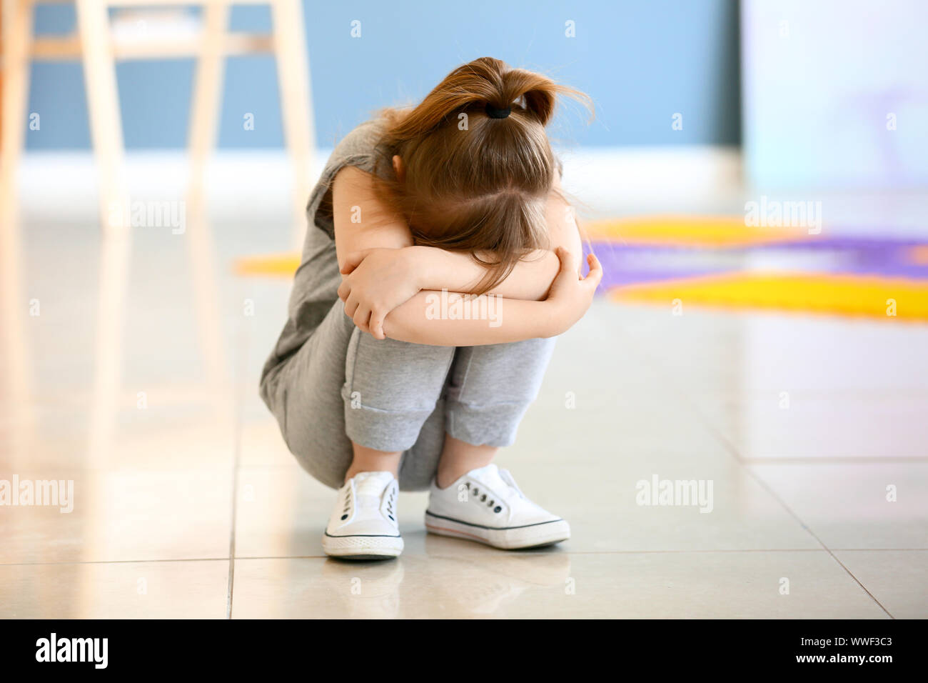 Sad little girl with autistic disorder in playroom Stock Photo - Alamy