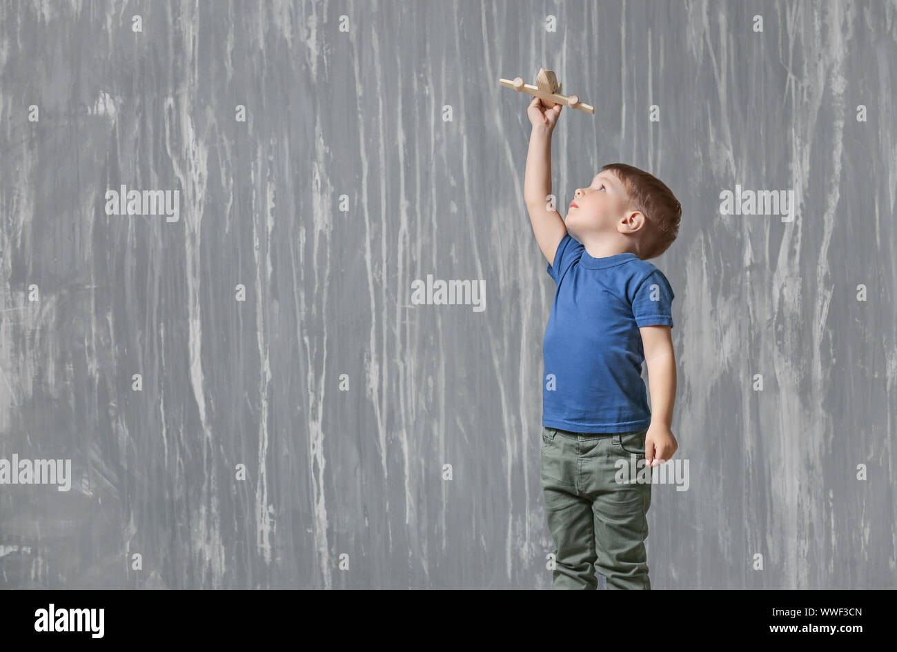 Little boy with autistic disorder playing with toy on grunge background ...