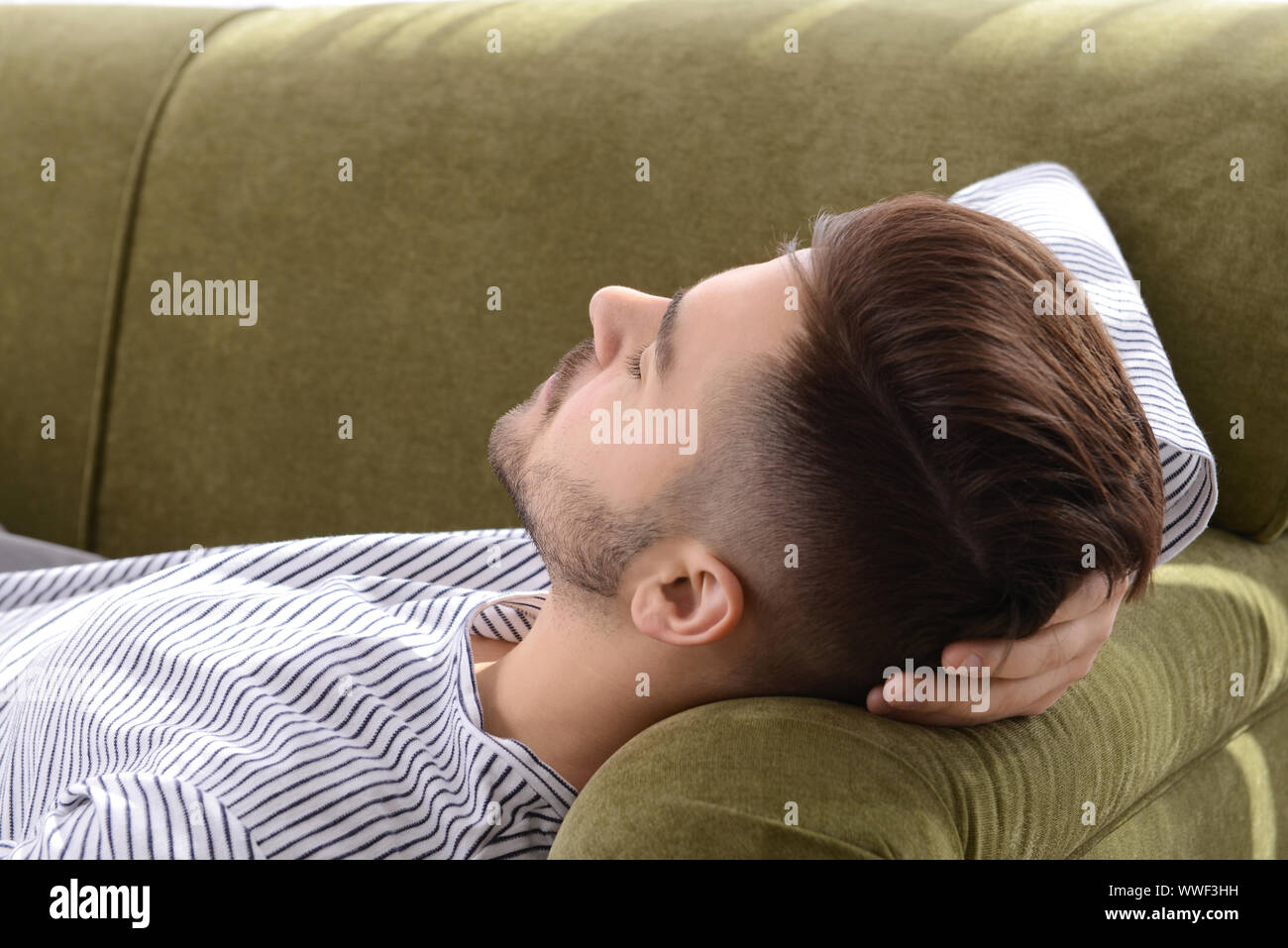Handsome man sleeping on sofa at home Stock Photo - Alamy