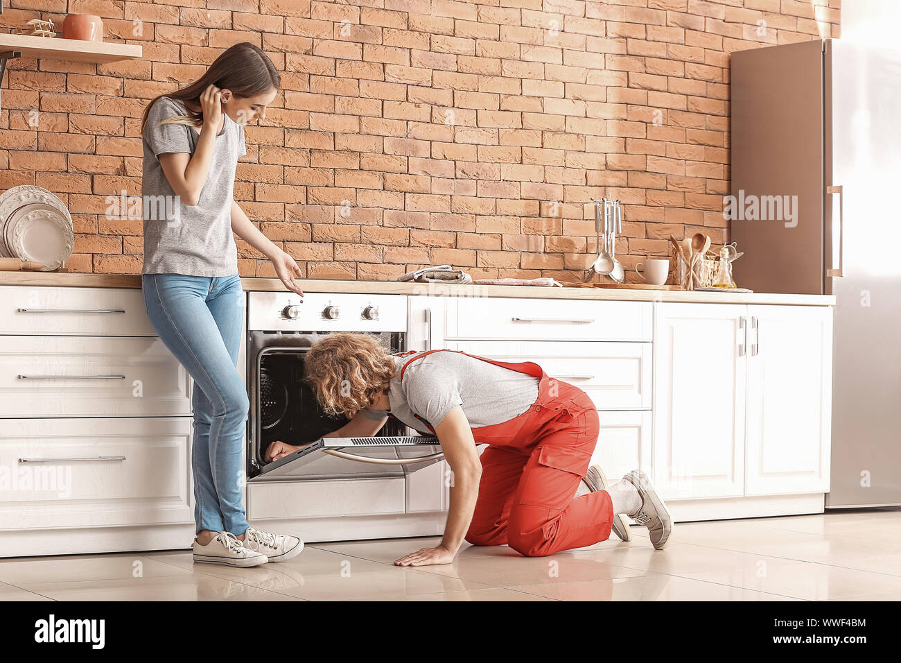 Worker repairing oven in kitchen Stock Photo - Alamy