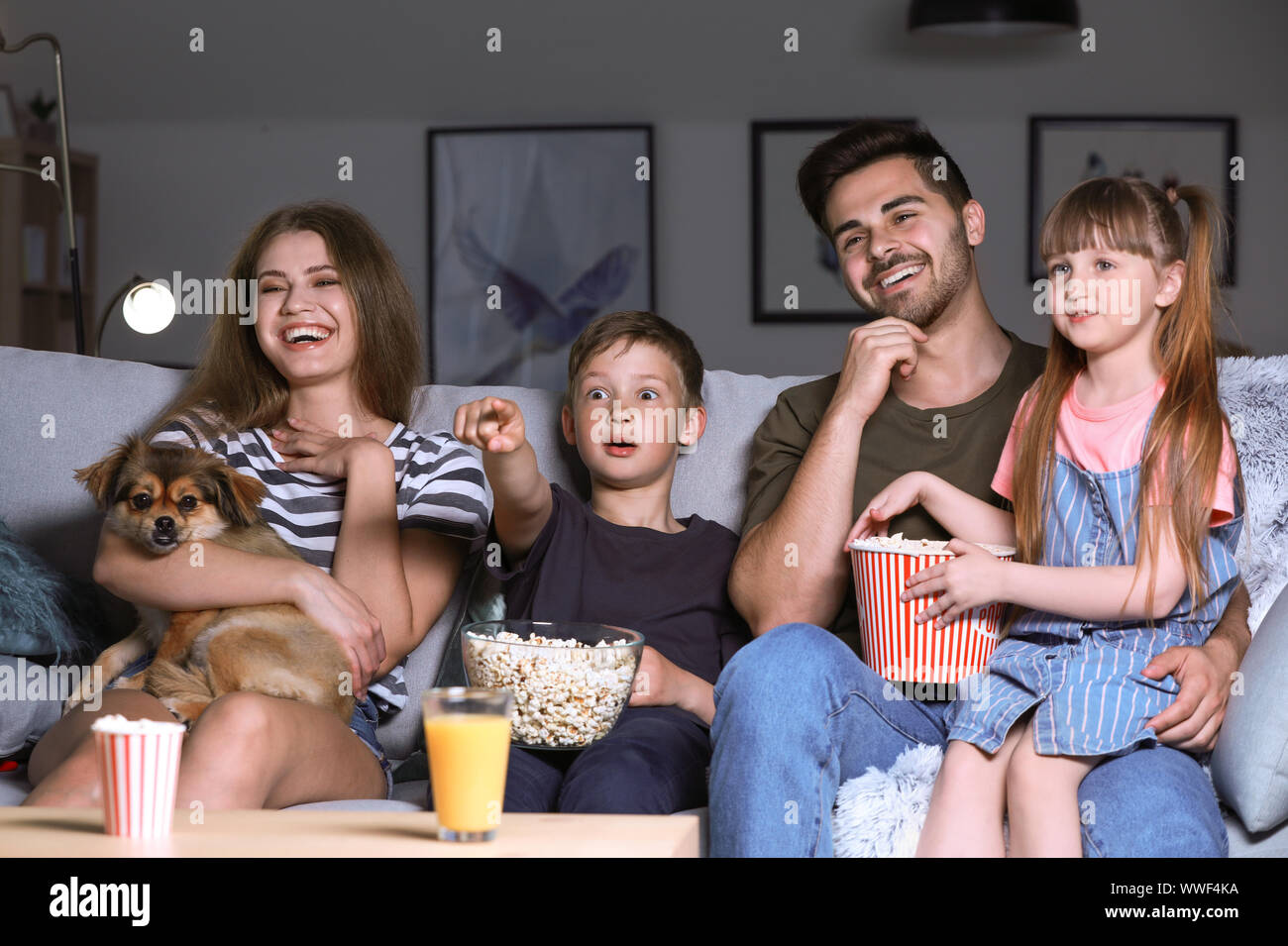 Happy family watching TV in evening Stock Photo - Alamy