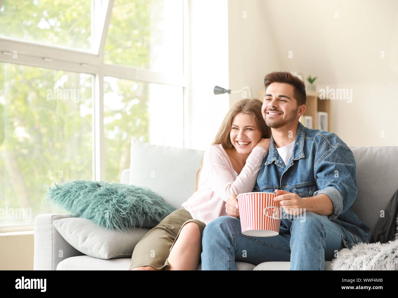 Happy couple watching TV at home Stock Photo - Alamy