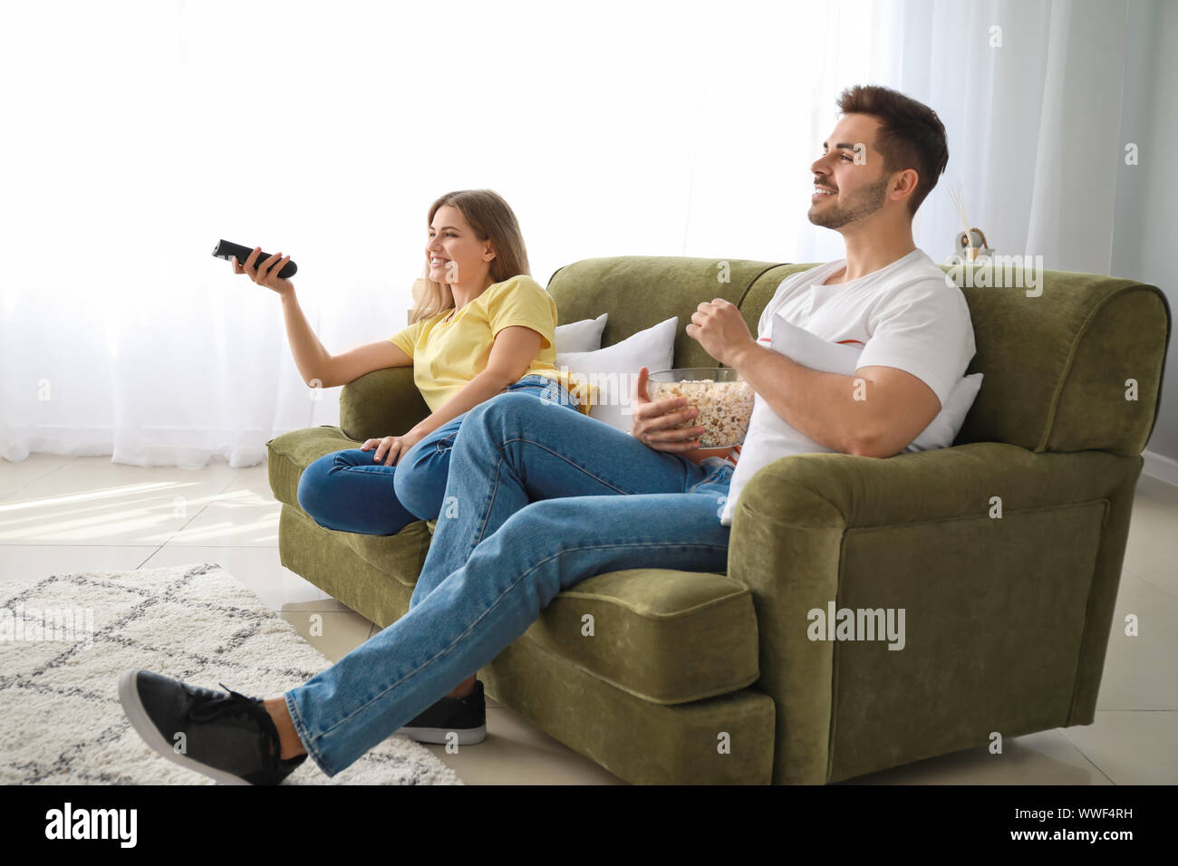 Happy couple watching TV at home Stock Photo - Alamy