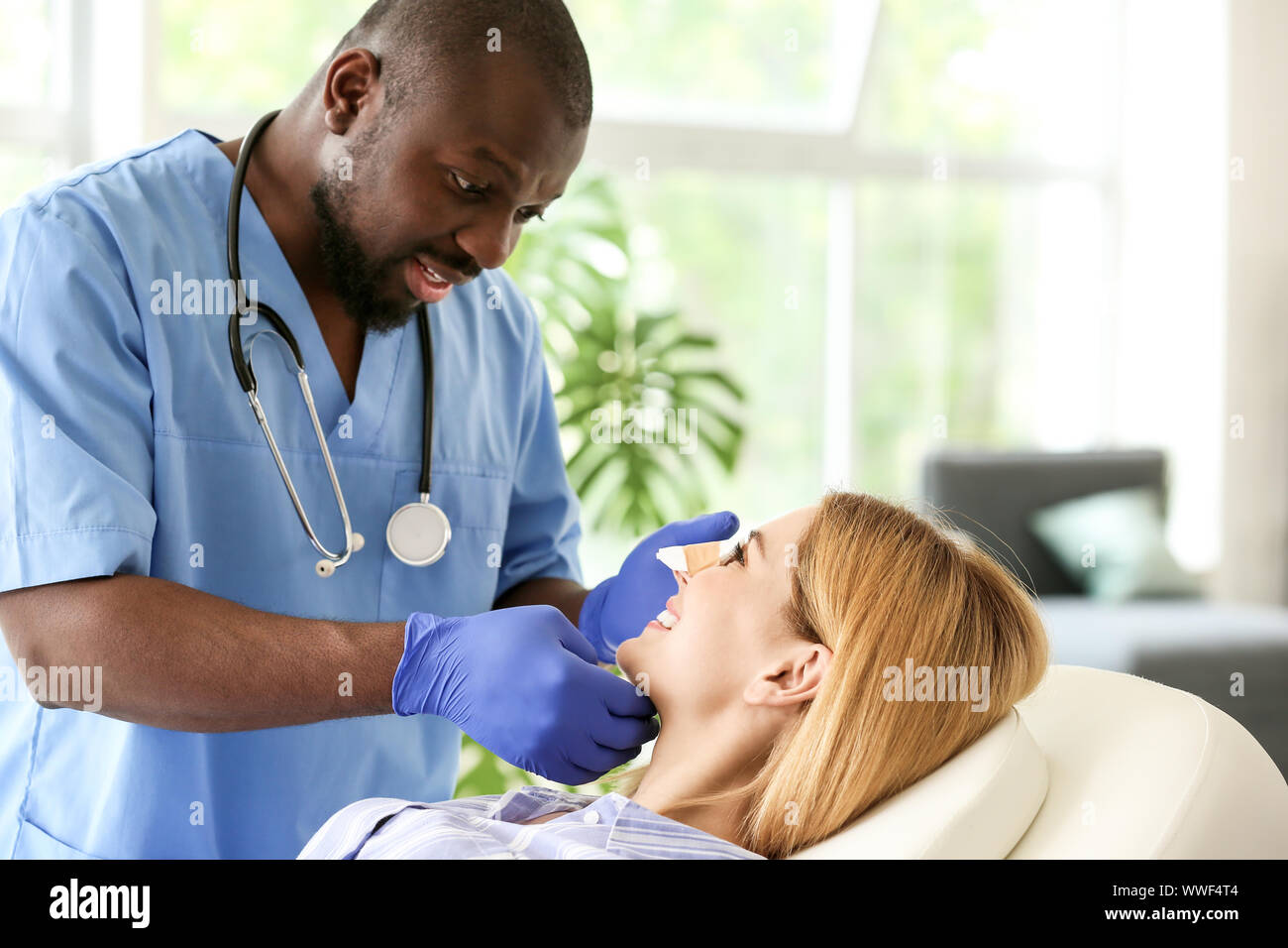 Plastic surgeon examining woman after operation in clinic Stock Photo ...