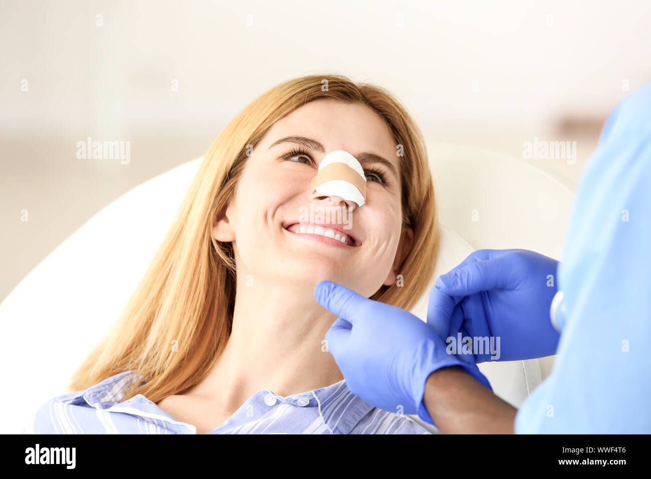 Plastic surgeon examining woman after operation in clinic Stock Photo ...