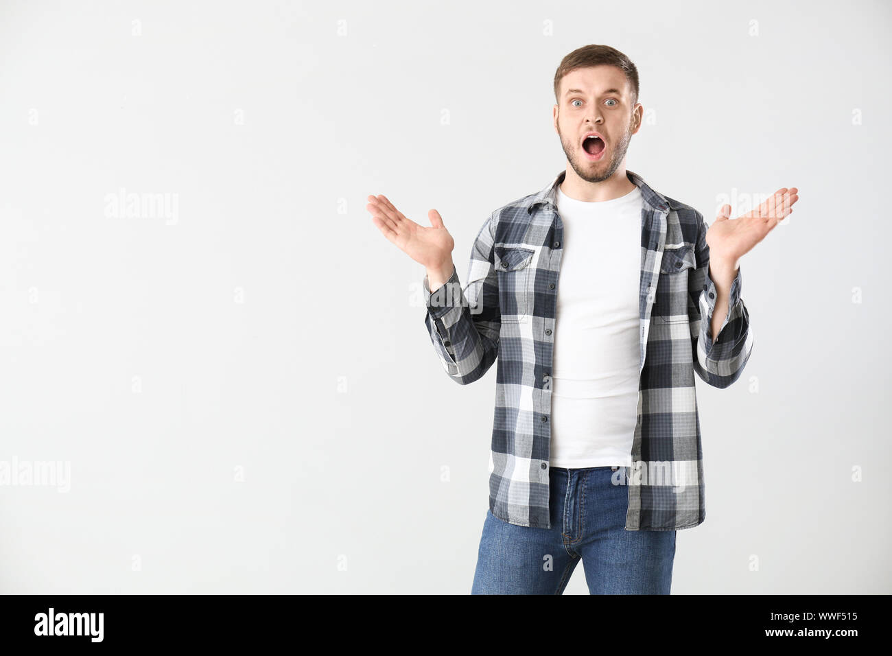 Shocked young man on light background Stock Photo - Alamy