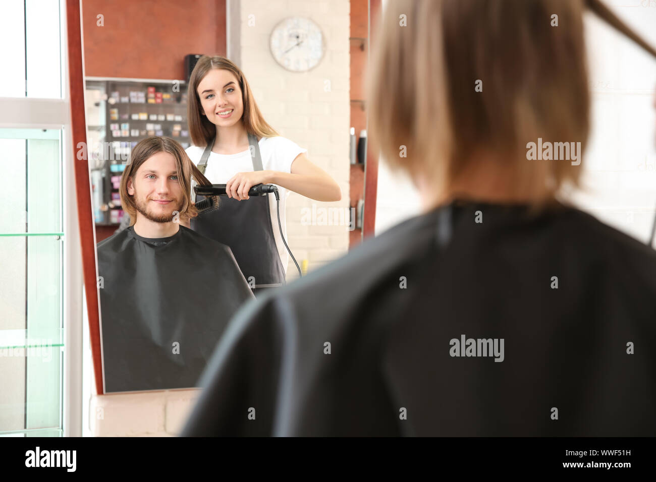 Reflection of female hairdresser working with client in salon Stock ...