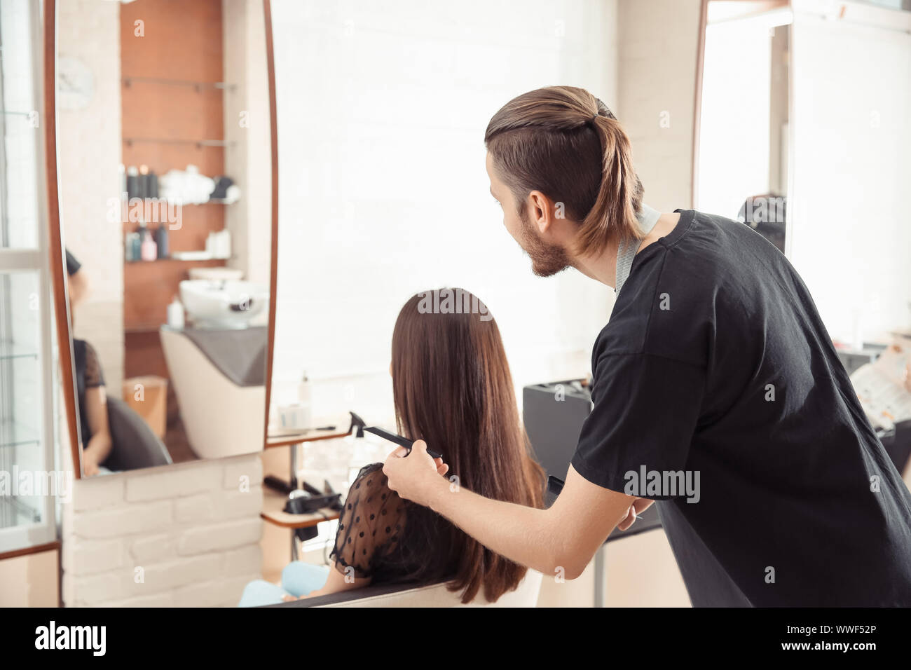Male hairdresser working with client in salon Stock Photo - Alamy