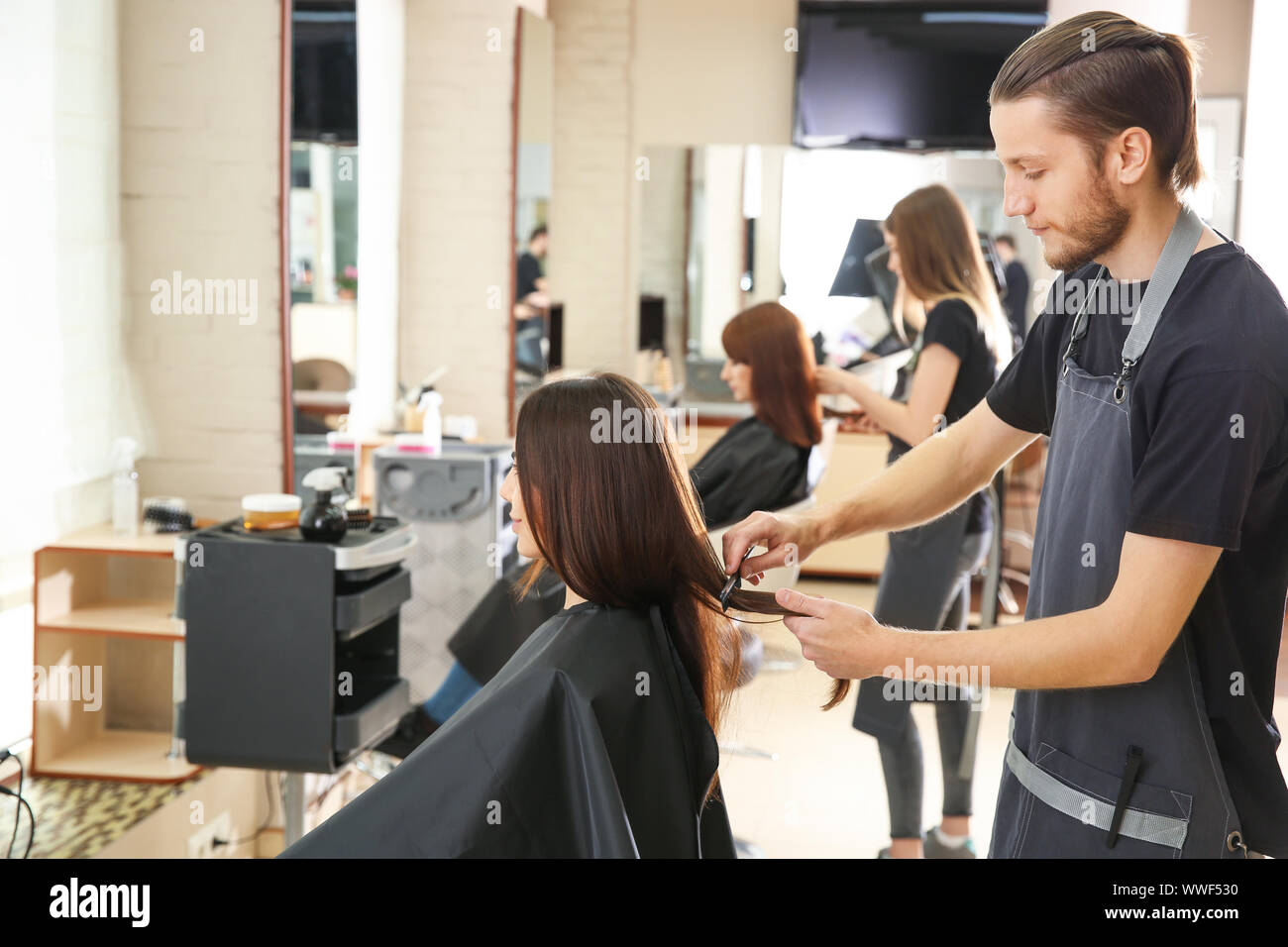 Male hairdresser working with client in salon Stock Photo - Alamy