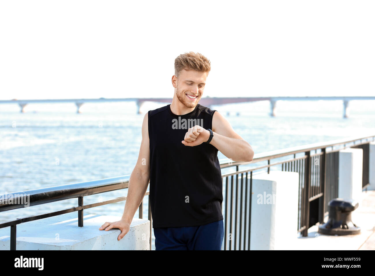 Sporty young man checking his pulse outdoors Stock Photo - Alamy