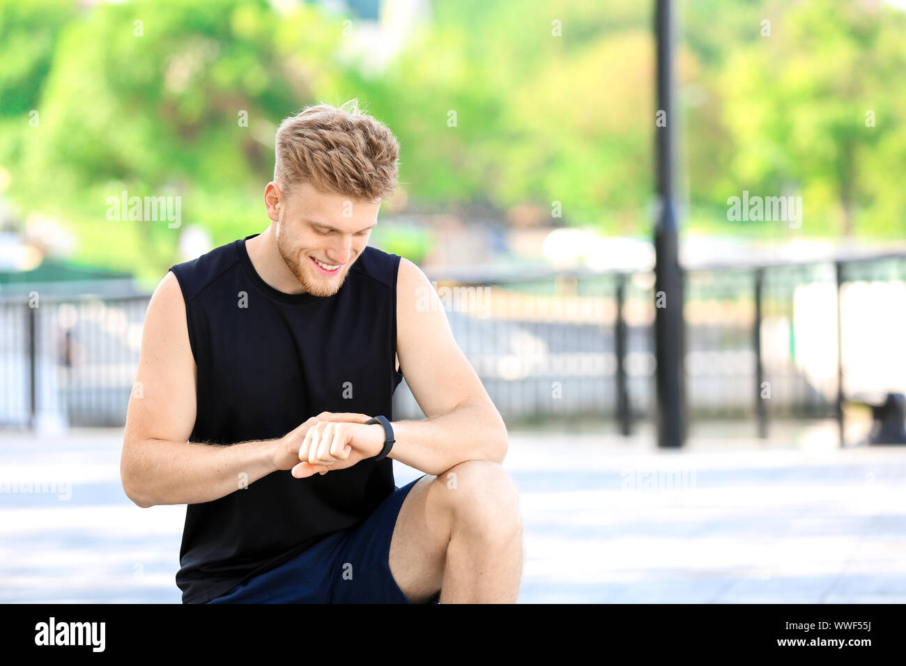 Sporty young man checking his pulse outdoors Stock Photo - Alamy