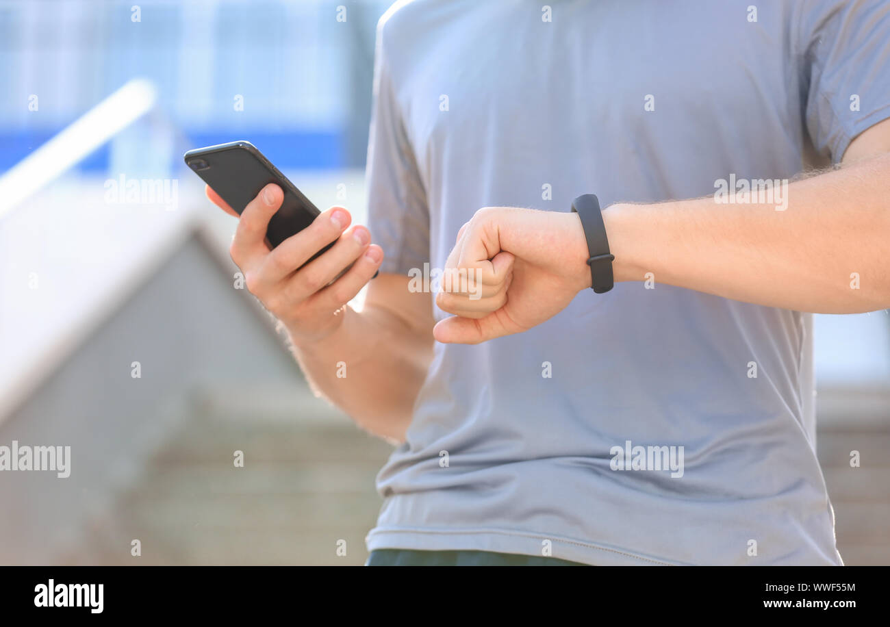 Sporty young man checking his pulse outdoors Stock Photo - Alamy