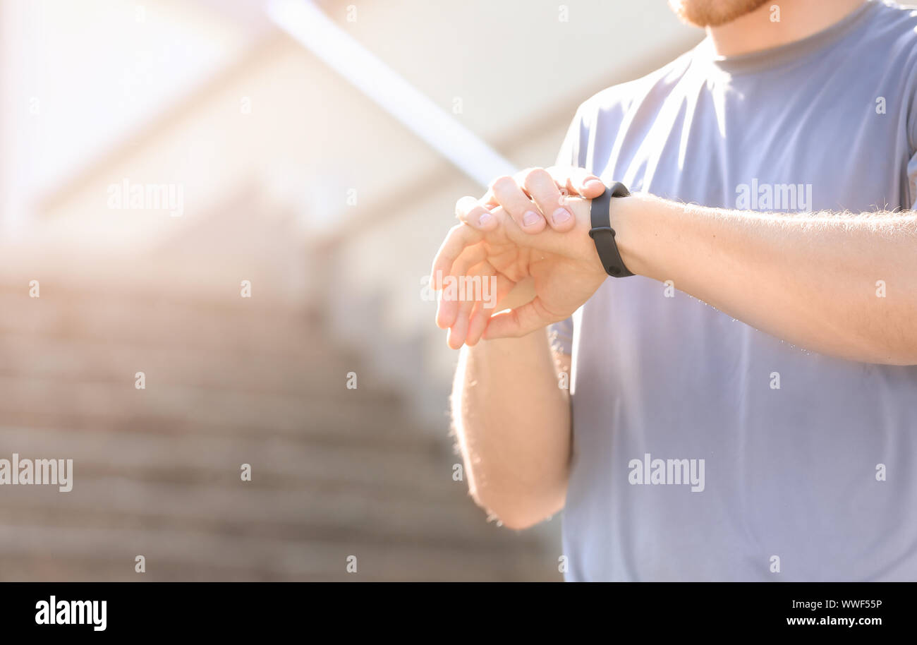 Sporty young man checking his pulse outdoors Stock Photo - Alamy