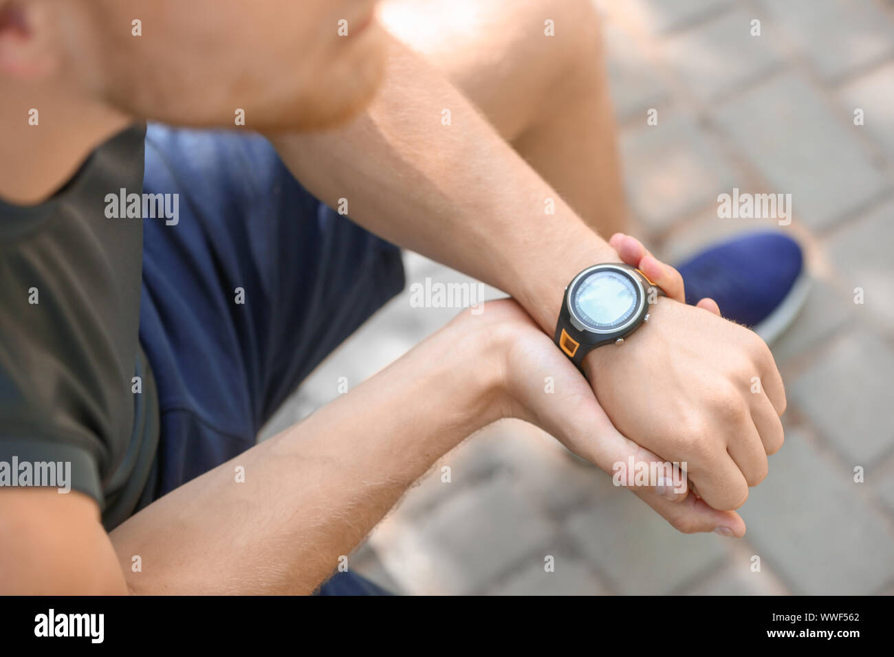 Sporty young man checking his pulse outdoors, closeup Stock Photo - Alamy
