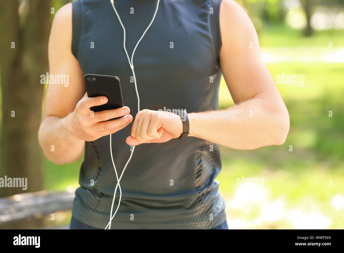 Sporty young man checking his pulse outdoors Stock Photo - Alamy
