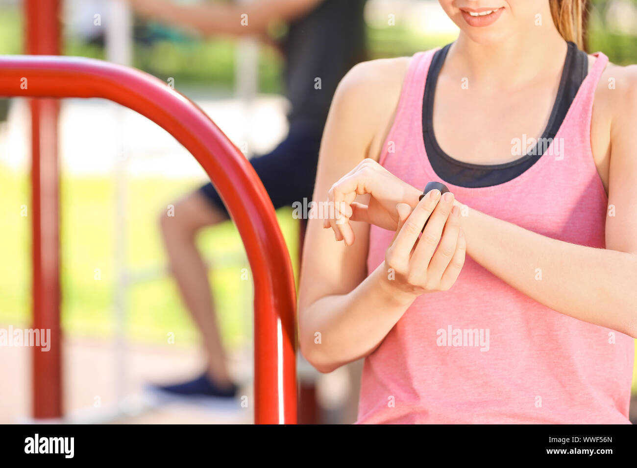 Sporty young woman checking her pulse outdoors Stock Photo - Alamy