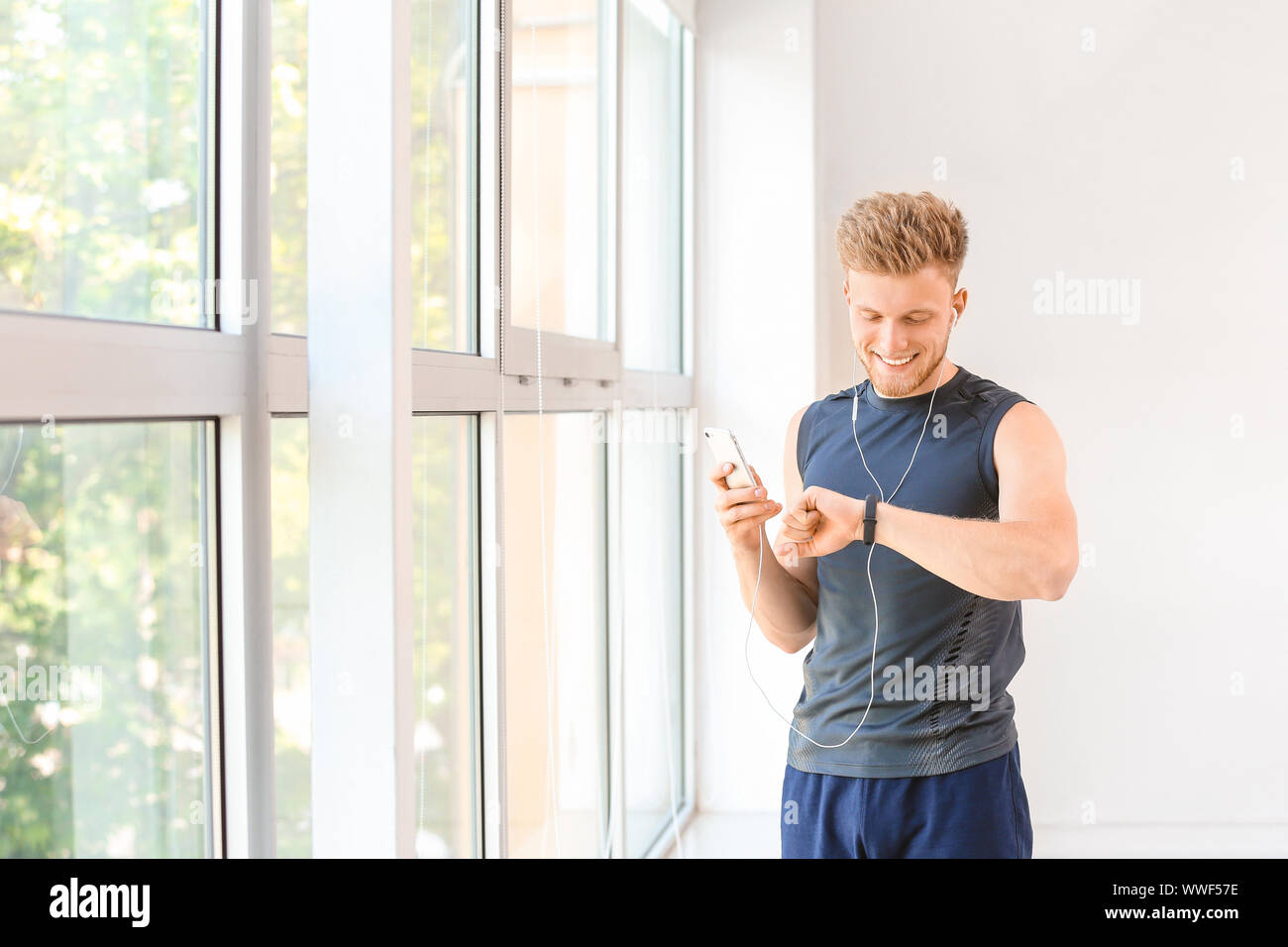 Sporty young man checking his pulse after training in gym Stock Photo ...