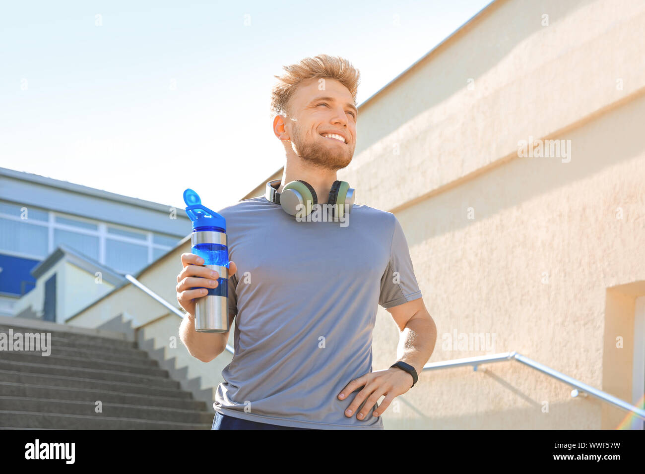 Sporty young man drinking water after training outdoors Stock Photo - Alamy